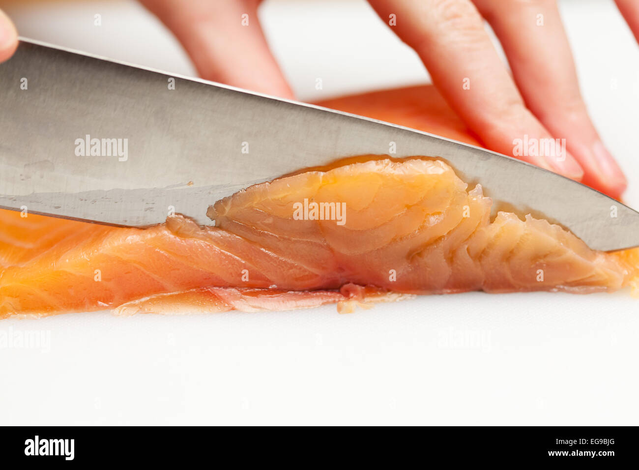 Cutting a piece of fish for sushi on a white table Stock Photo - Alamy