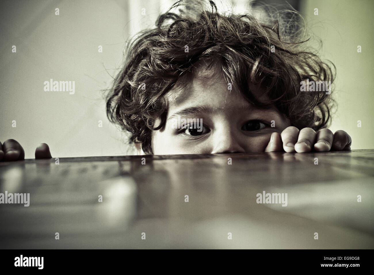 Children looking over table edge hi-res stock photography and images ...