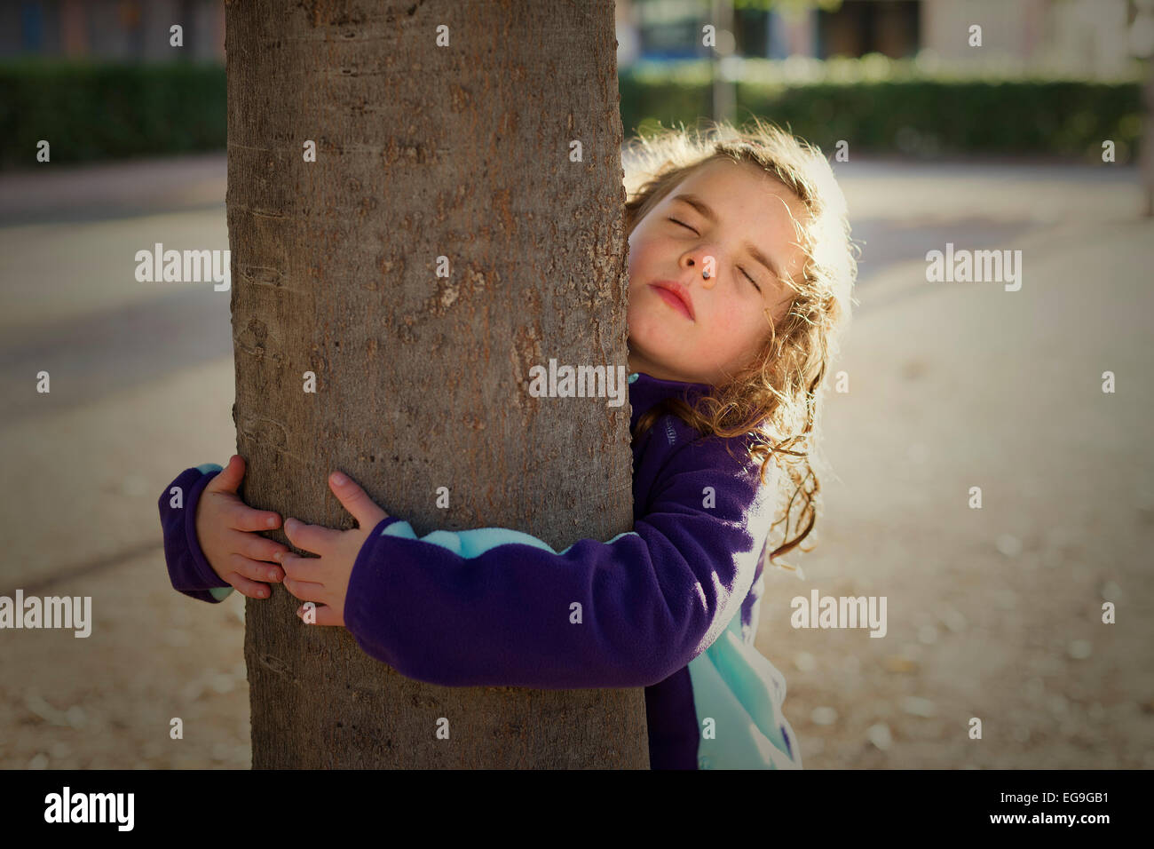 Girl hugging a tree Stock Photo - Alamy