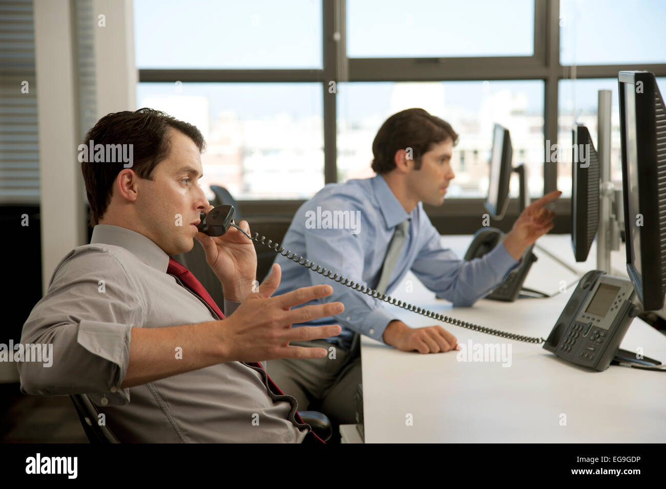 Two men working at desk in office Stock Photo - Alamy