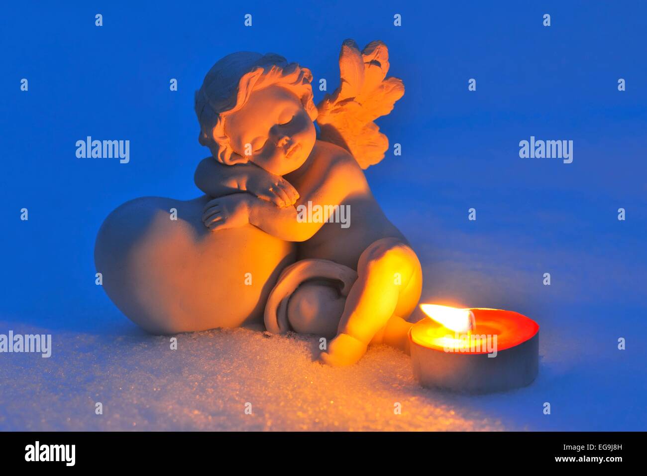 Porcelain figure, angel in the snow, with a tea light Stock Photo - Alamy
