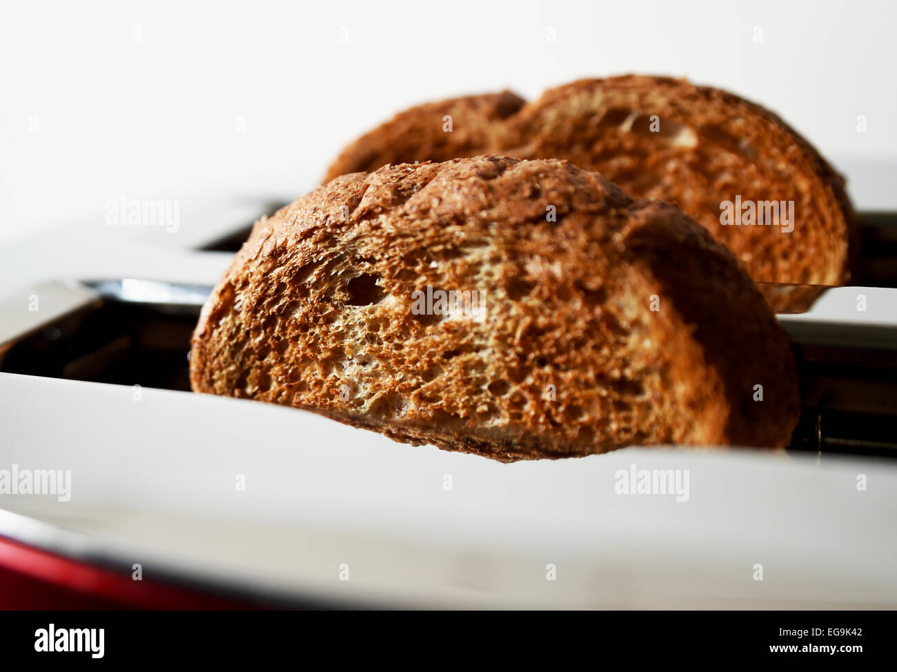 Electrical toaster in kitchen with cooked toast made from brown bread ...
