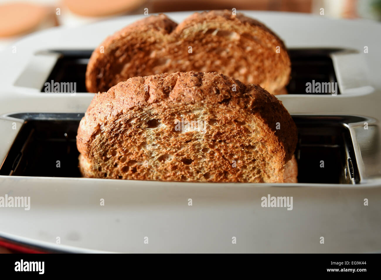 Electrical toaster in kitchen with cooked toast made from brown bread ...
