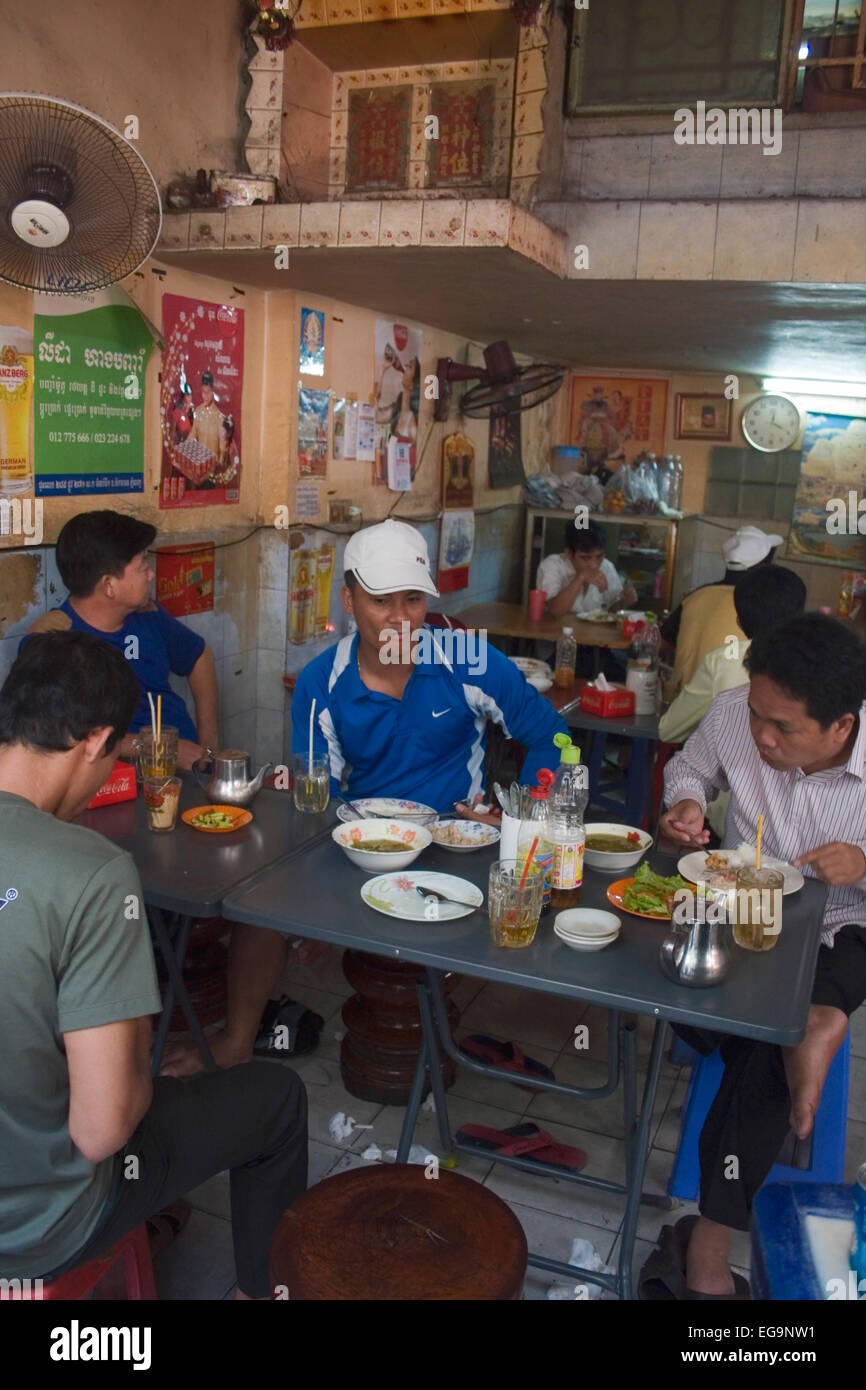 A group of men are eating street food on a table in lunch spot in Phnom ...