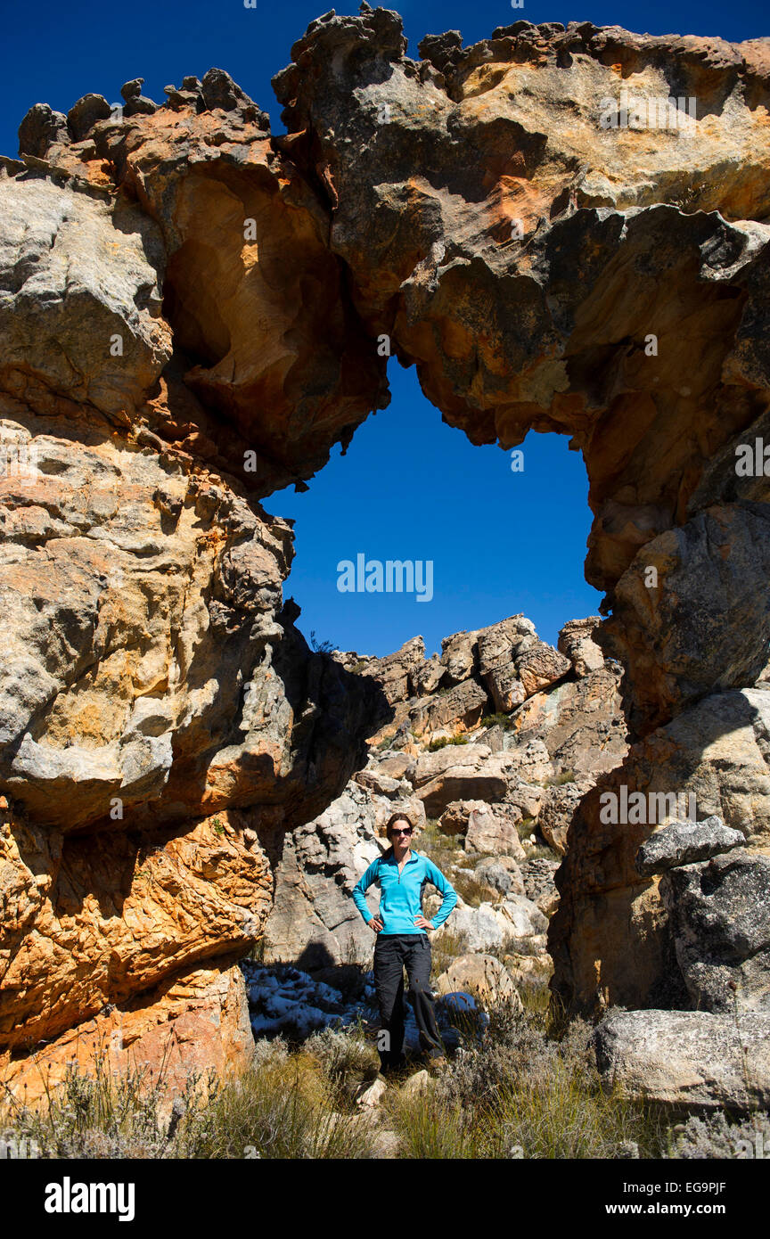Hiker passing rockformations on the way to Wolfberg Arch, Cederberg ...