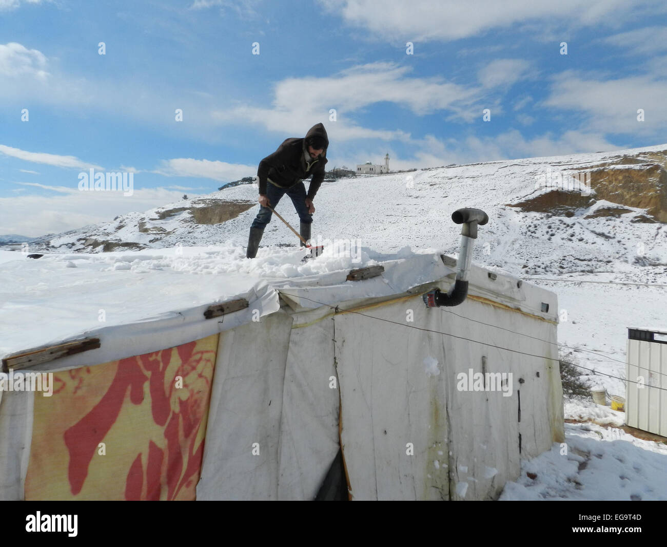 Beirut, Lebanon. 20th Feb, 2015. A Syrian refugee clears snow on a tent ...