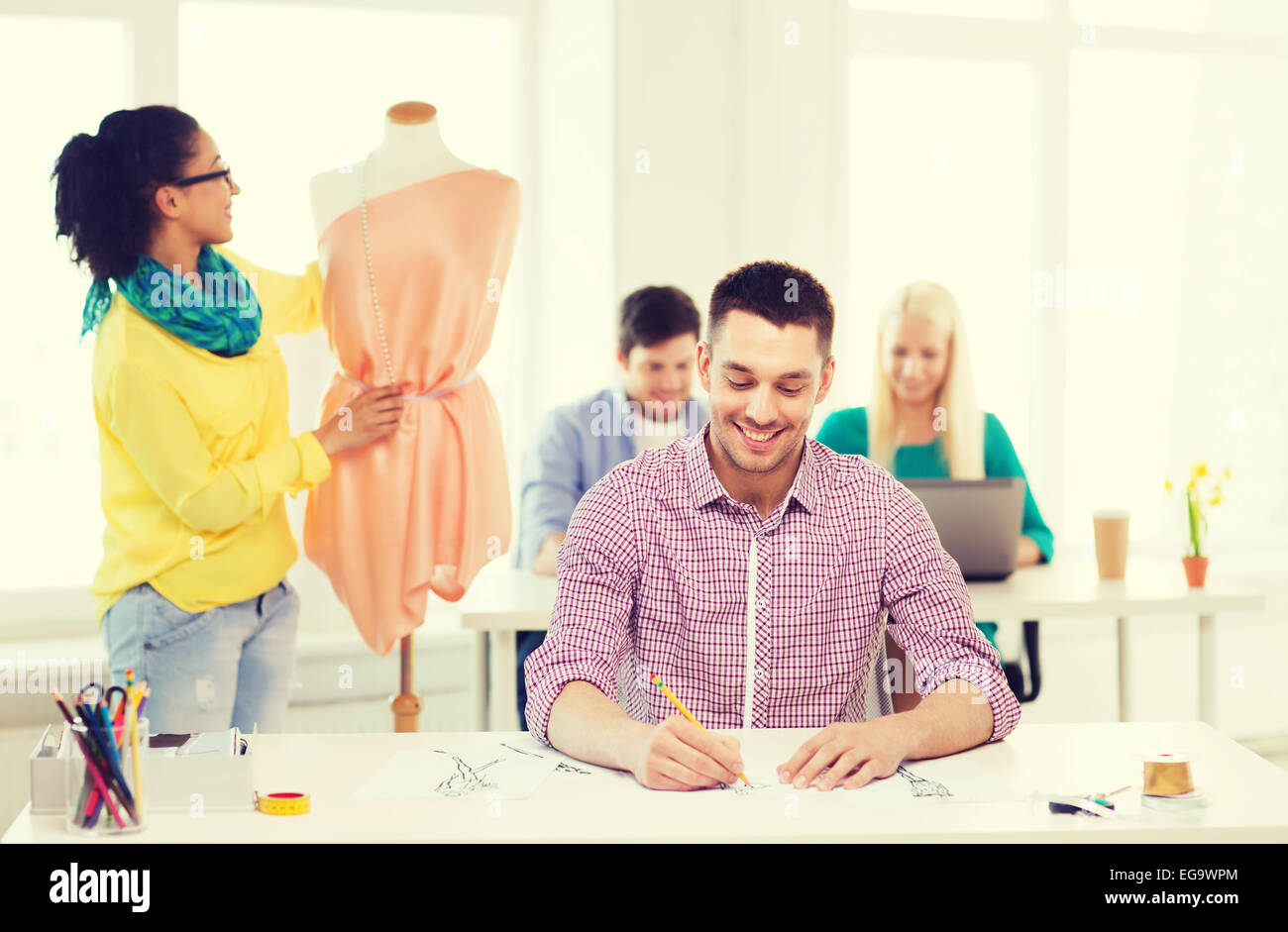 smiling fashion designers working in office Stock Photo - Alamy
