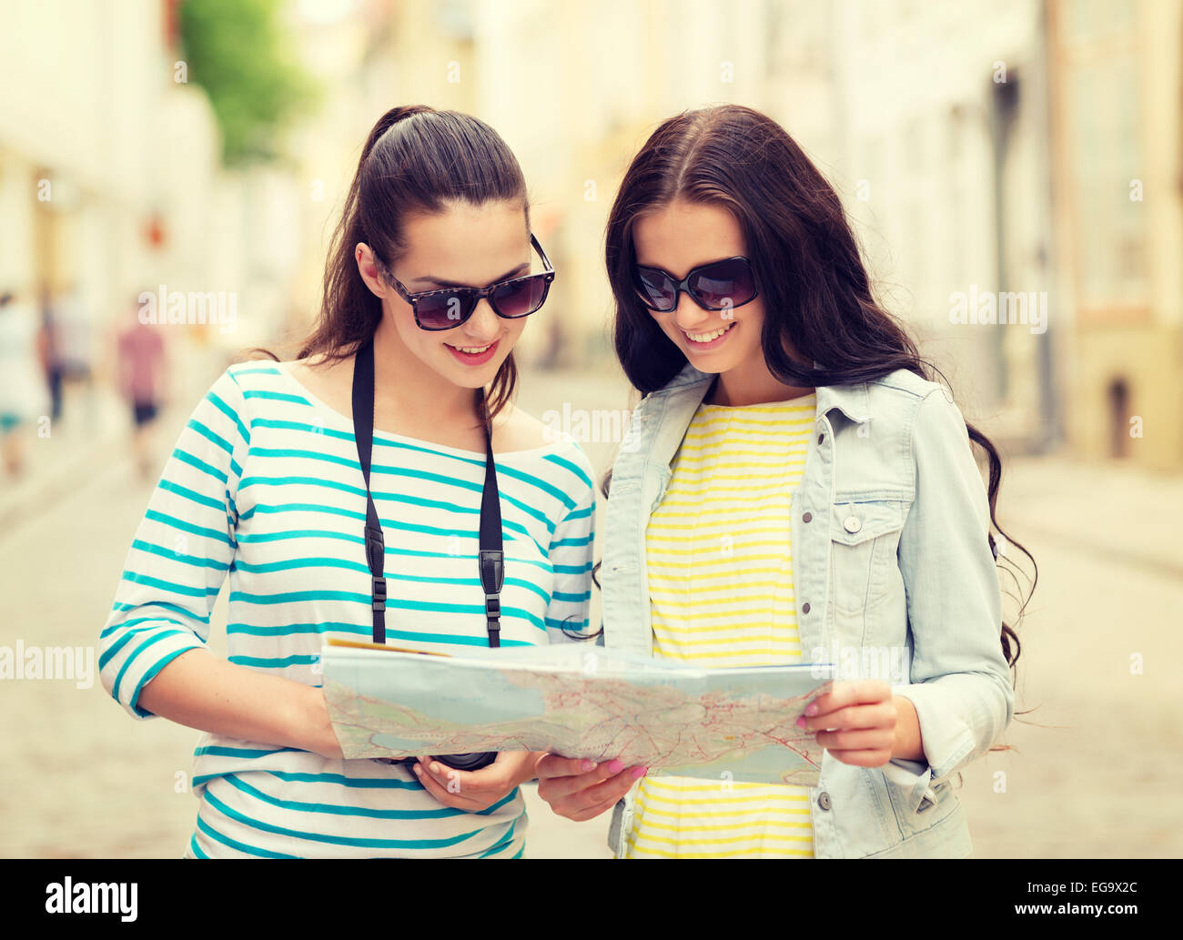 smiling teenage girls with map Stock Photo - Alamy