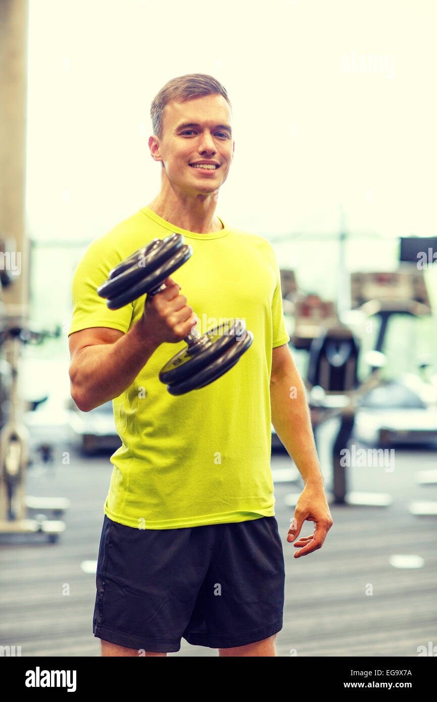 smiling man with dumbbell in gym Stock Photo - Alamy