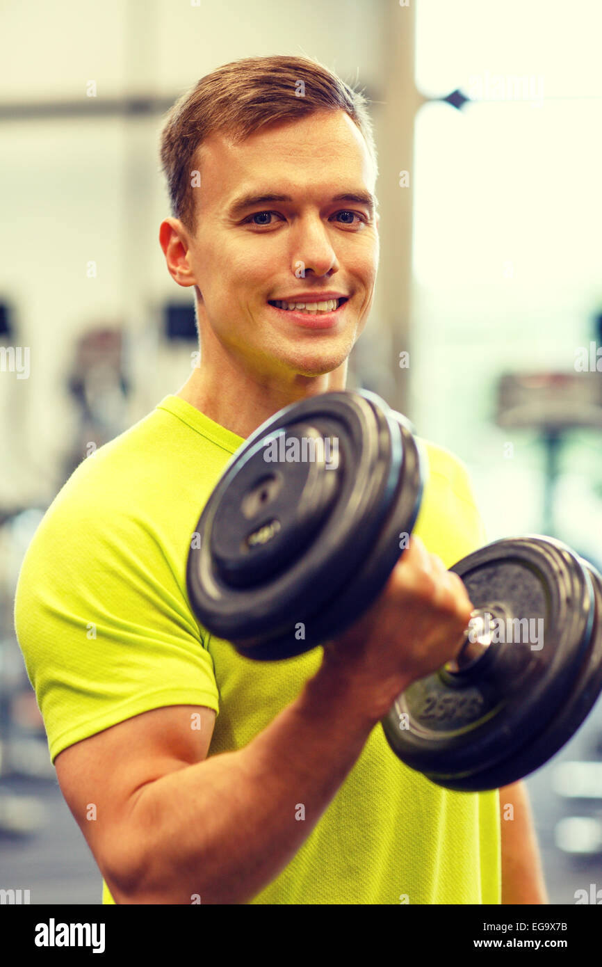 smiling man with dumbbell in gym Stock Photo - Alamy