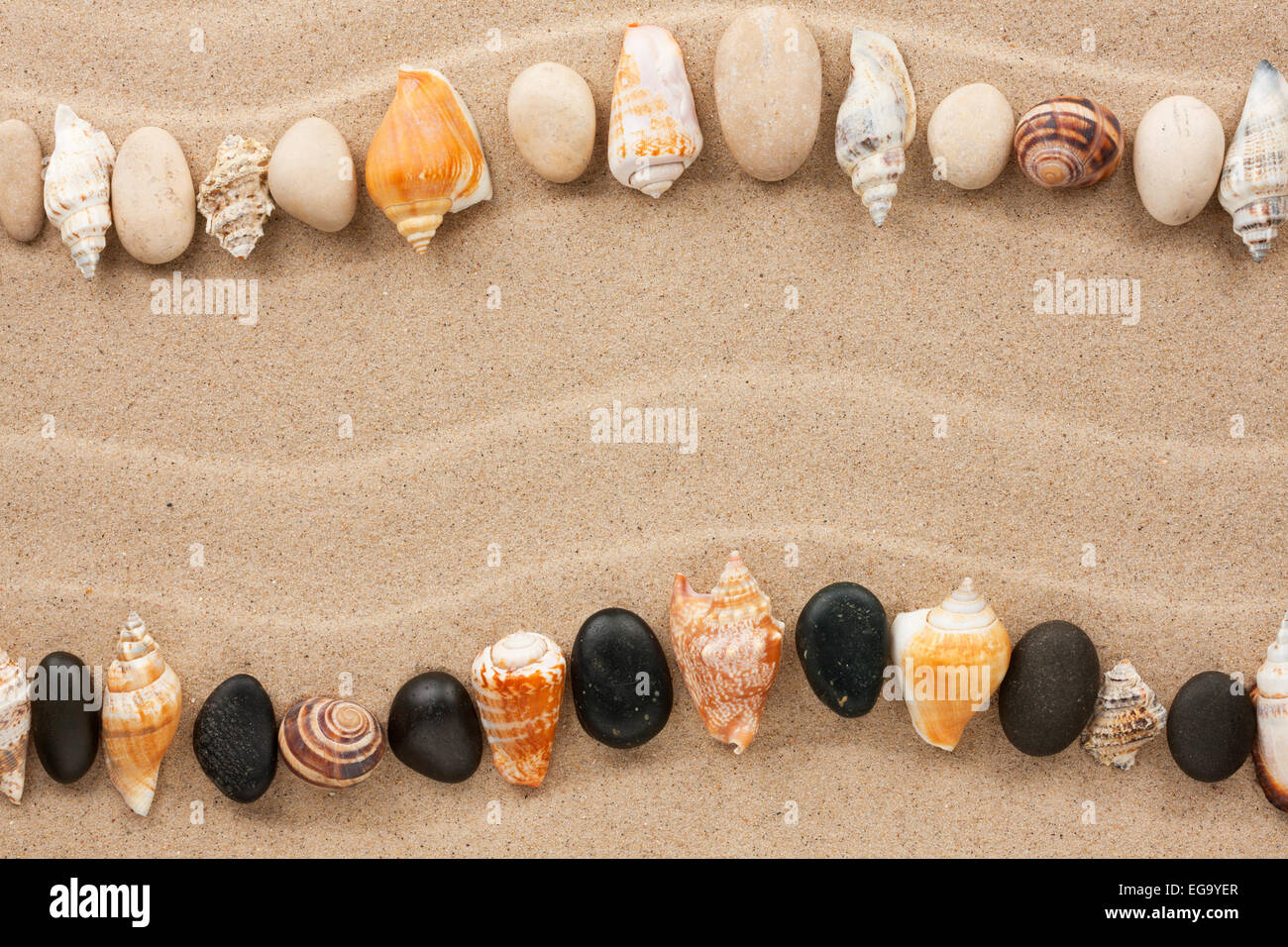 Stripe of sea shells and stones lying on the sand, with space for text ...