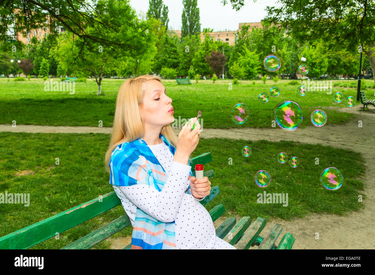 Pregnant park blowing bubbles bench Stock Photo - Alamy
