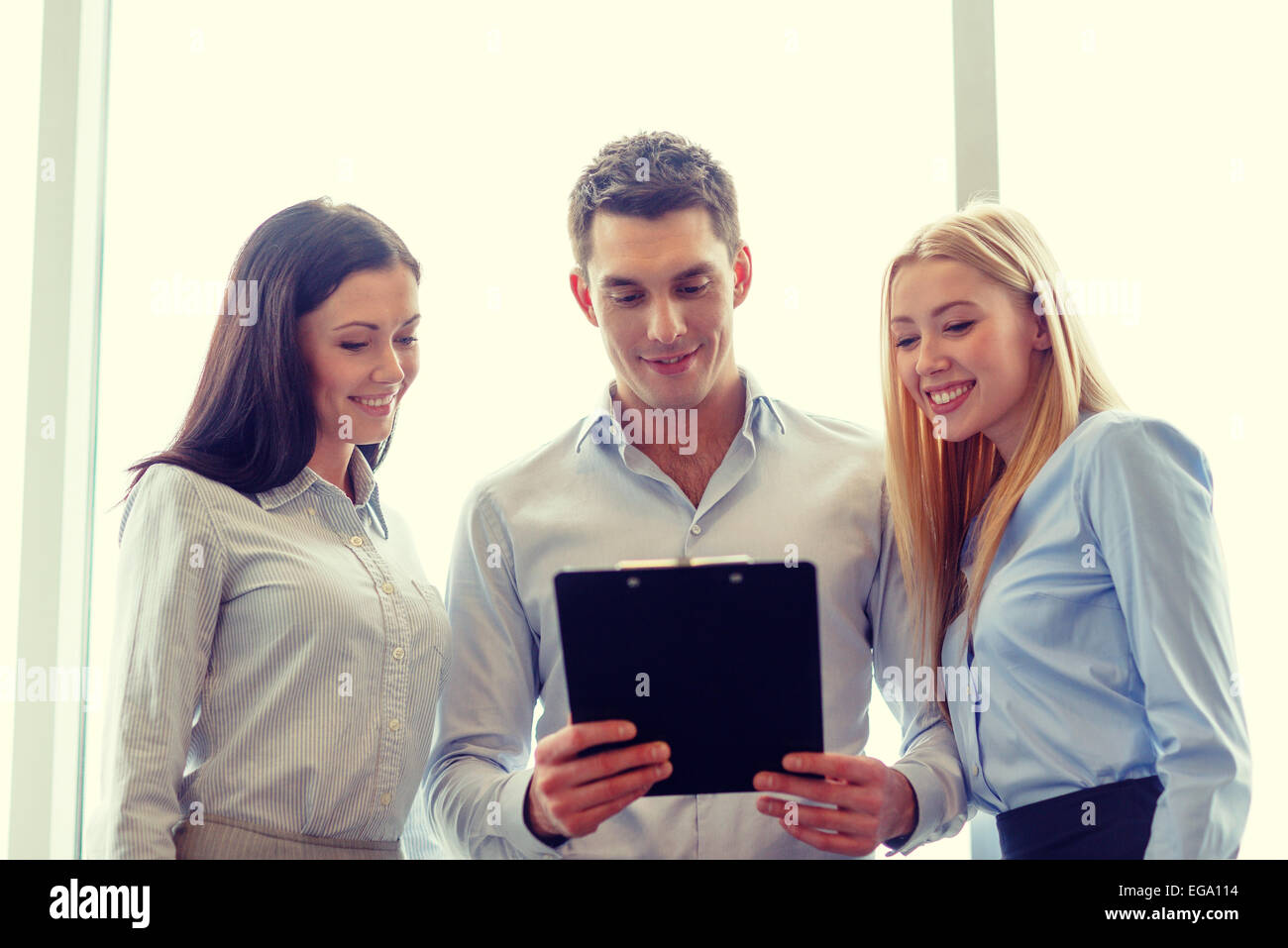 business team looking at clipboard Stock Photo - Alamy