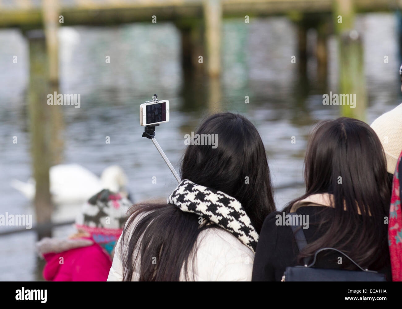 Take selfies using selfie sticks hi-res stock photography and images ...