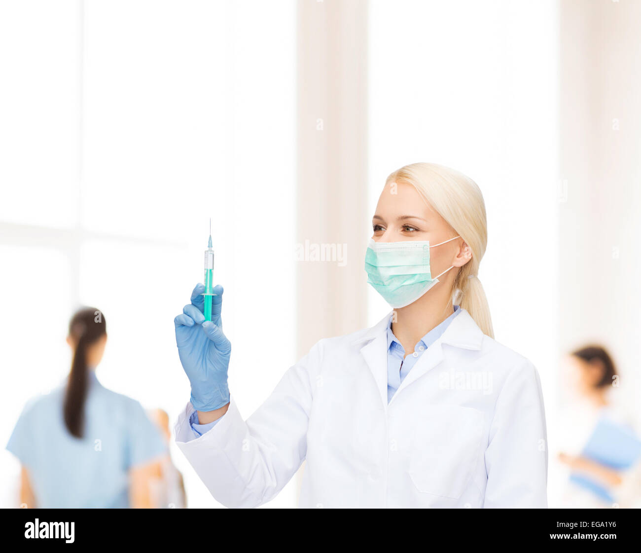 doctor in mask holding syringe with injection Stock Photo - Alamy
