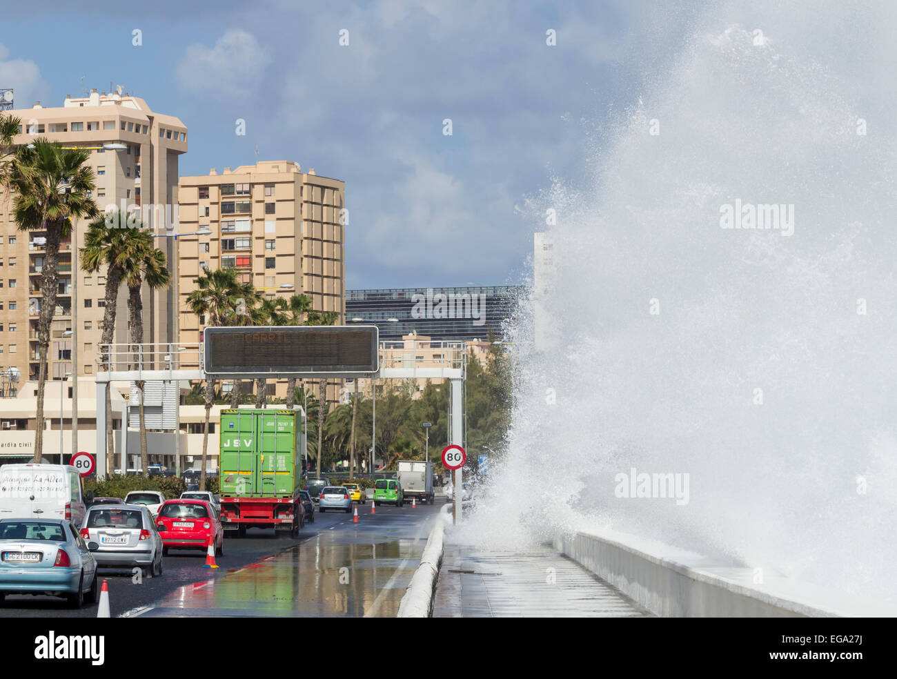 Waves crashing over sea wall onto road Stock Photo - Alamy