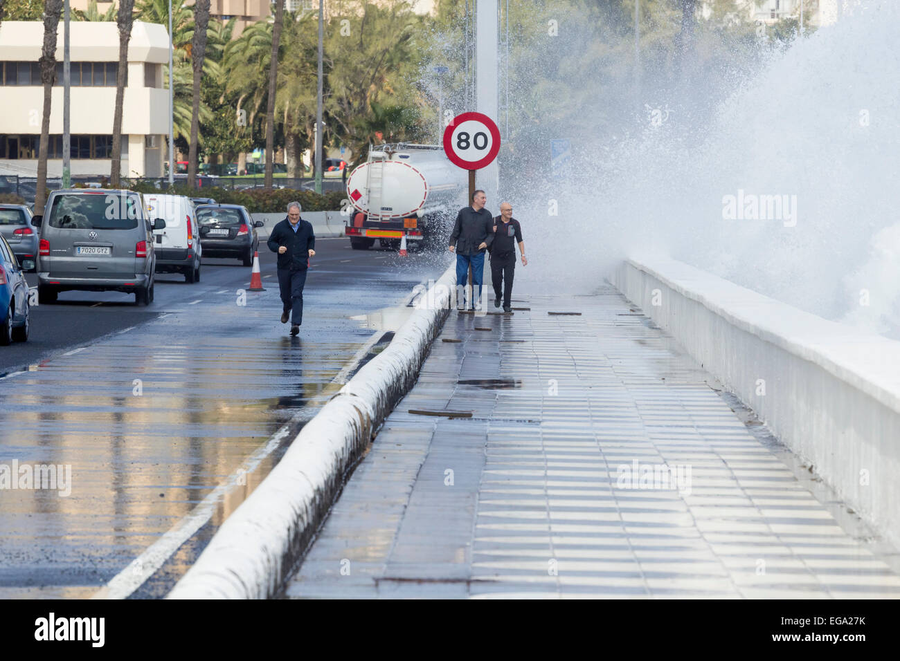 Waves crashing over sea wall onto road Stock Photo - Alamy