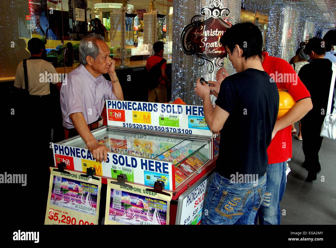Singapore: Merchant selling phone cards on the sidewalk in front of the ...