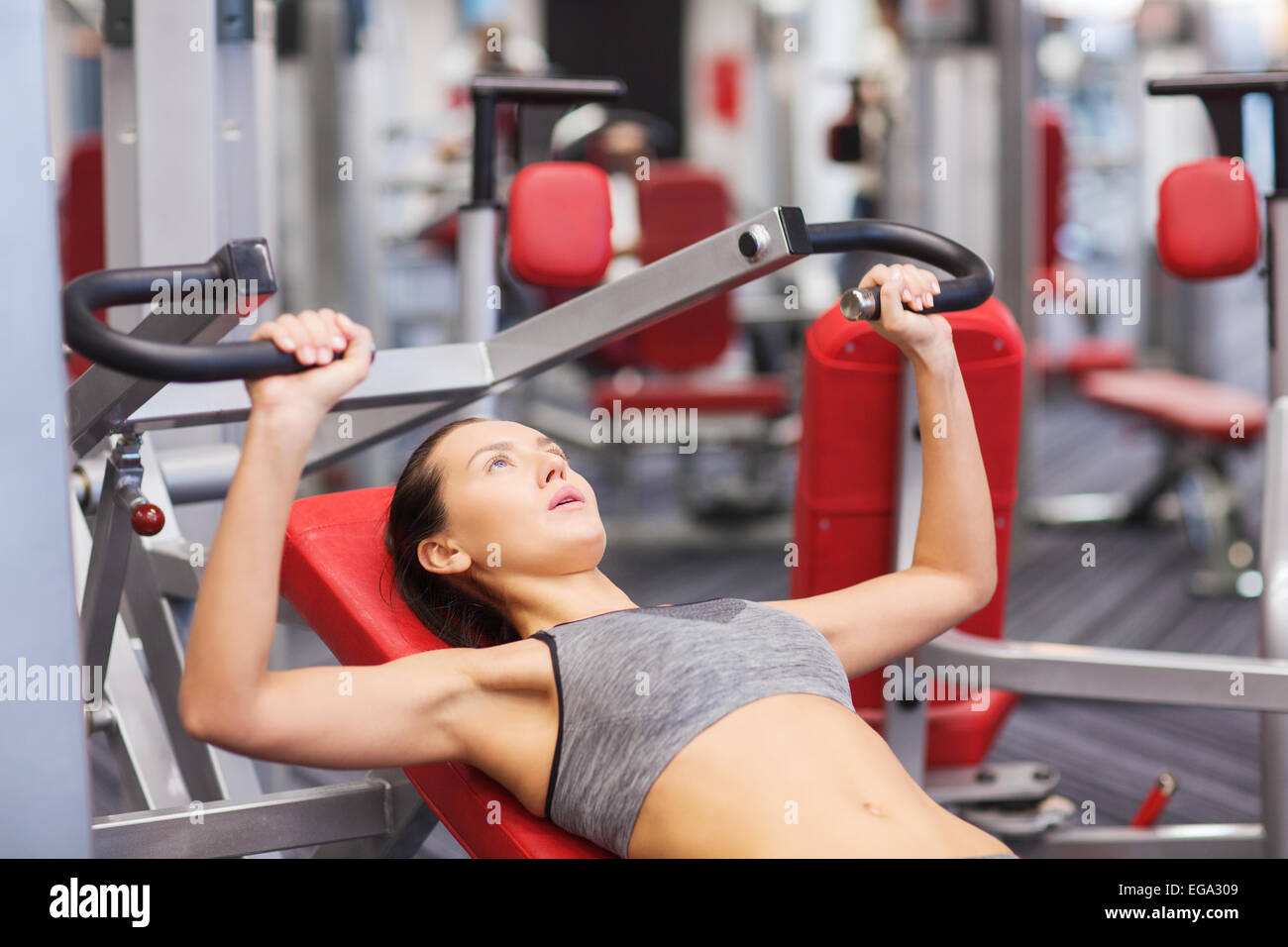 young woman exercising on gym machine Stock Photo - Alamy