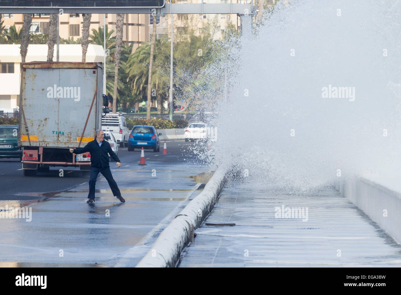 A man steps back as a huge wave crashes over sea wall Stock Photo - Alamy