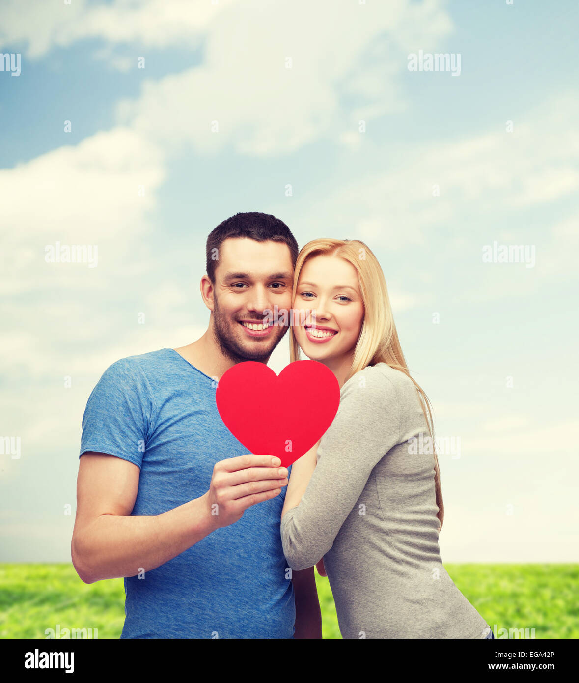 smiling couple holding big red heart Stock Photo - Alamy