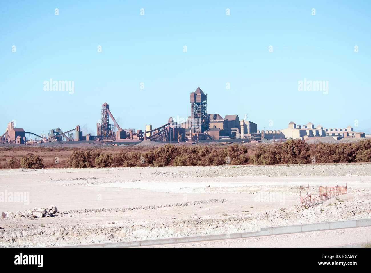 Steelworks and reddish dust of iron ore covering the landscape at ...