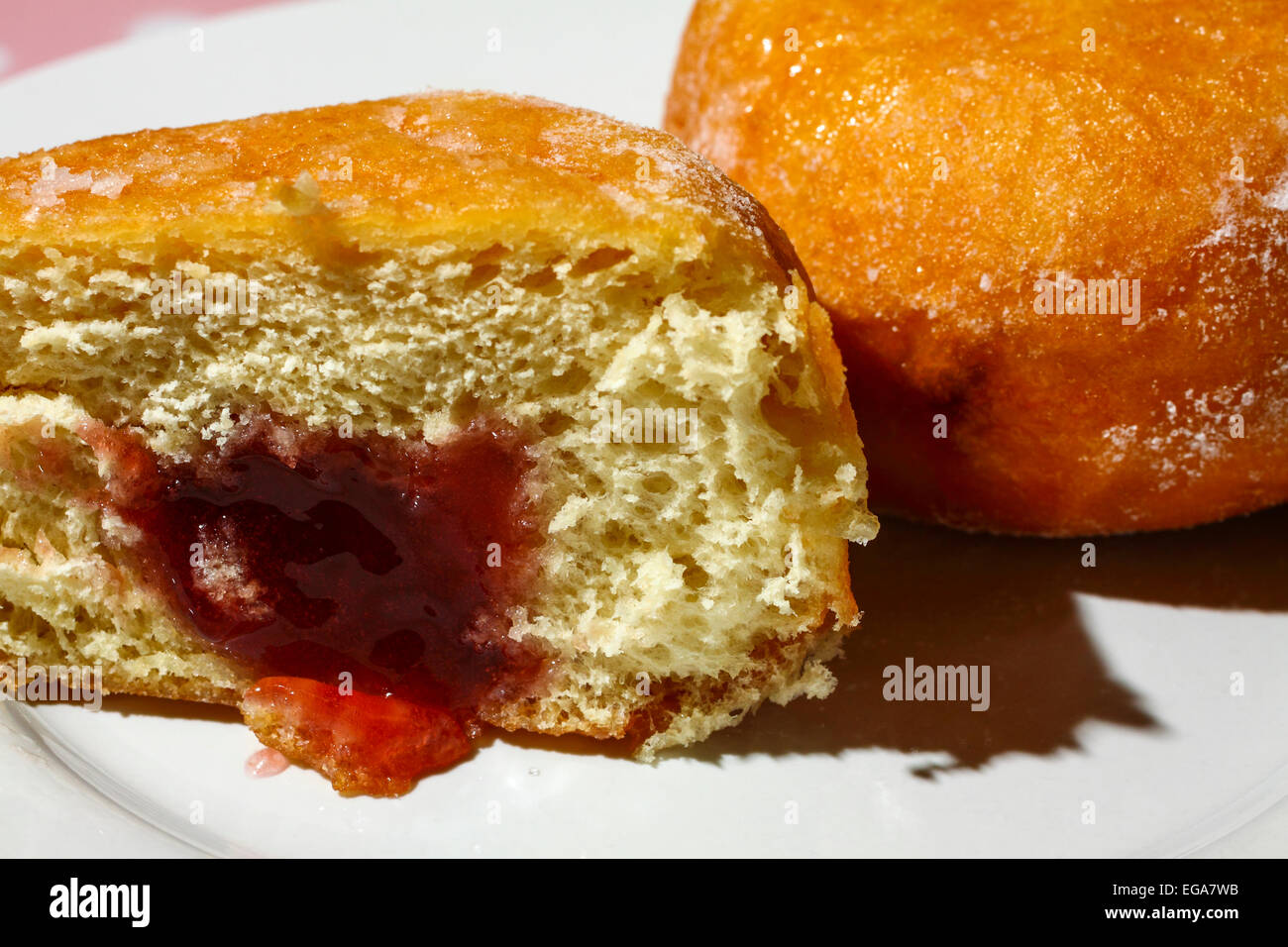 Doughnut on plate cut in half with jam oozing out Stock Photo - Alamy