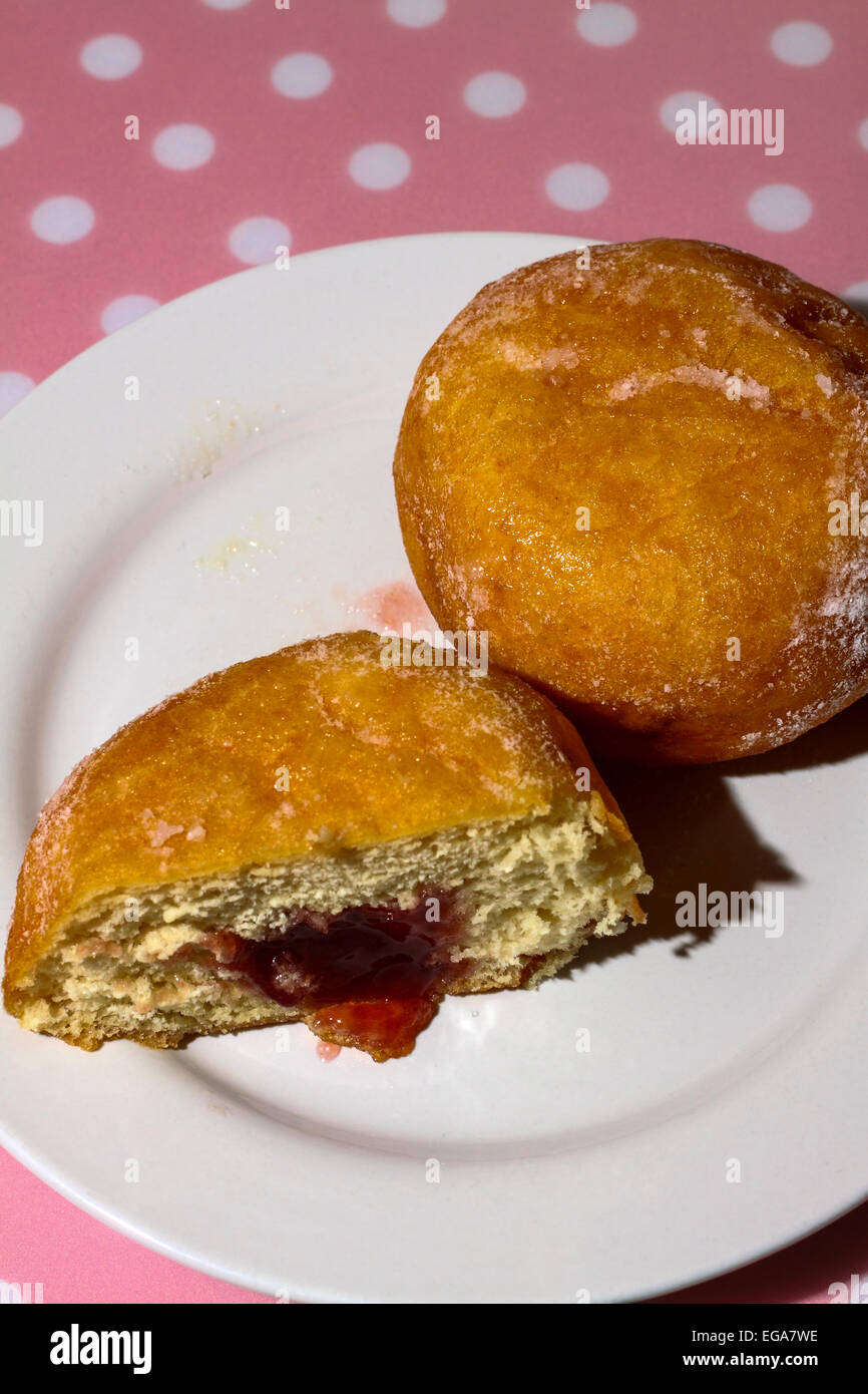Doughnut on plate cut in half with jam oozing out Stock Photo - Alamy