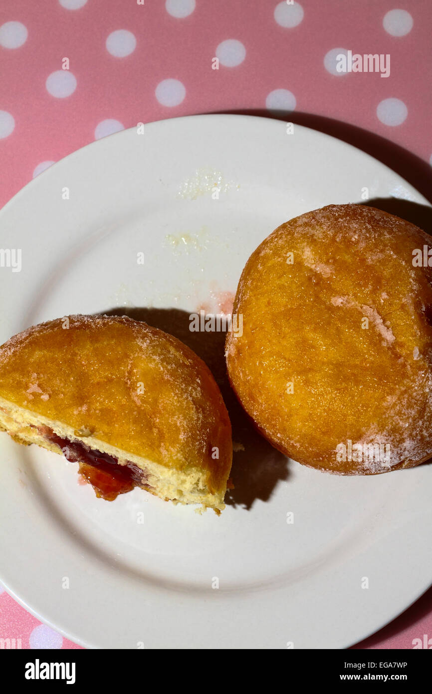 Doughnut on plate cut in half with jam oozing out Stock Photo - Alamy
