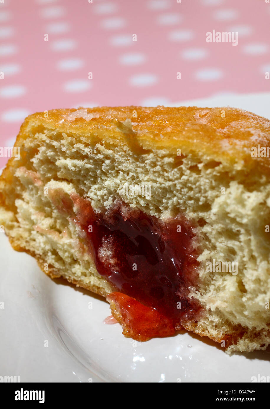 Doughnut on plate cut in half with jam oozing out Stock Photo - Alamy