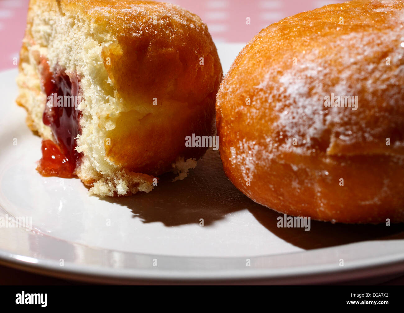 Doughnut on plate cut in half with jam oozing out Stock Photo - Alamy