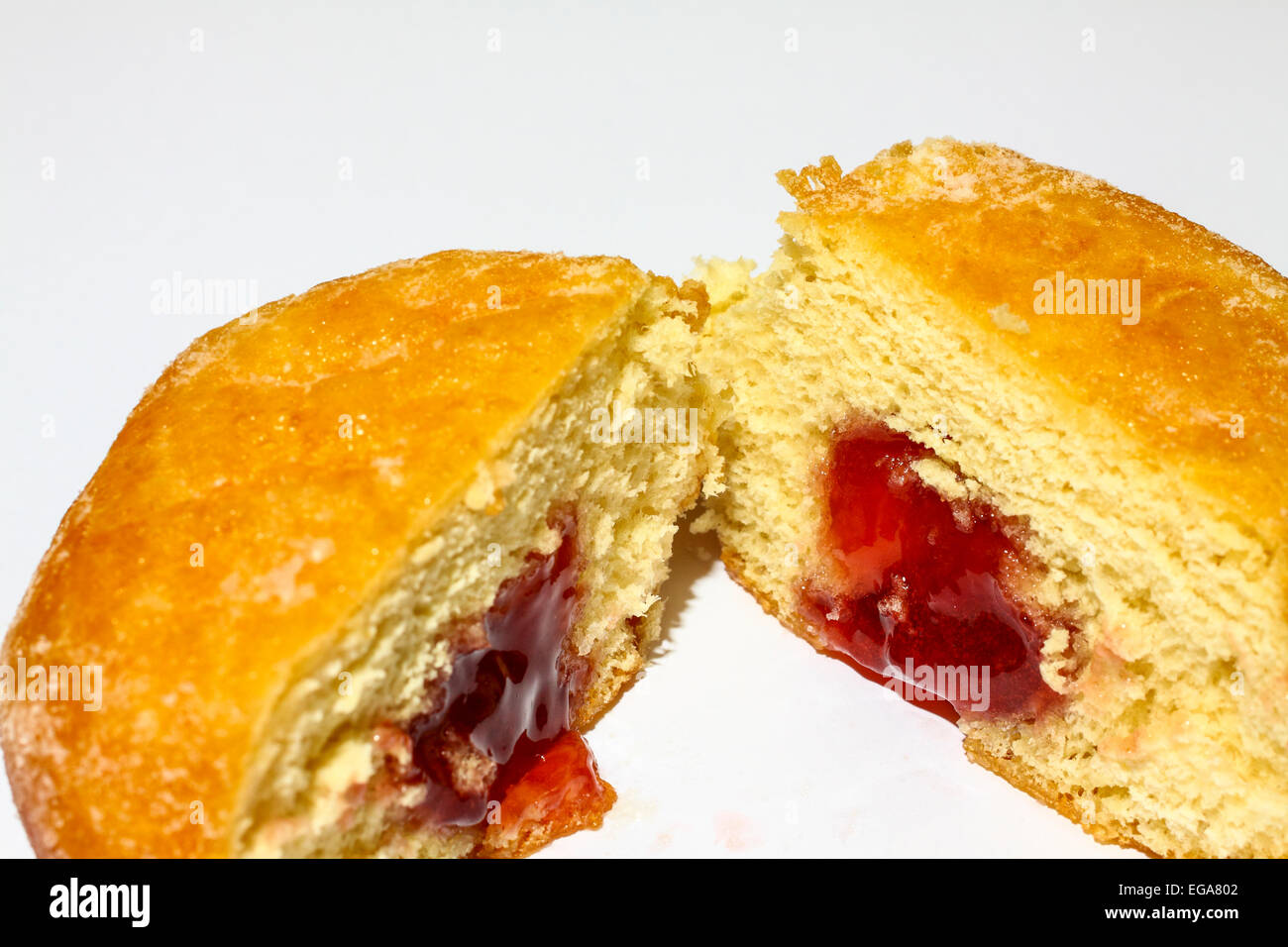 Doughnut sliced in half with jam oozing out Stock Photo - Alamy