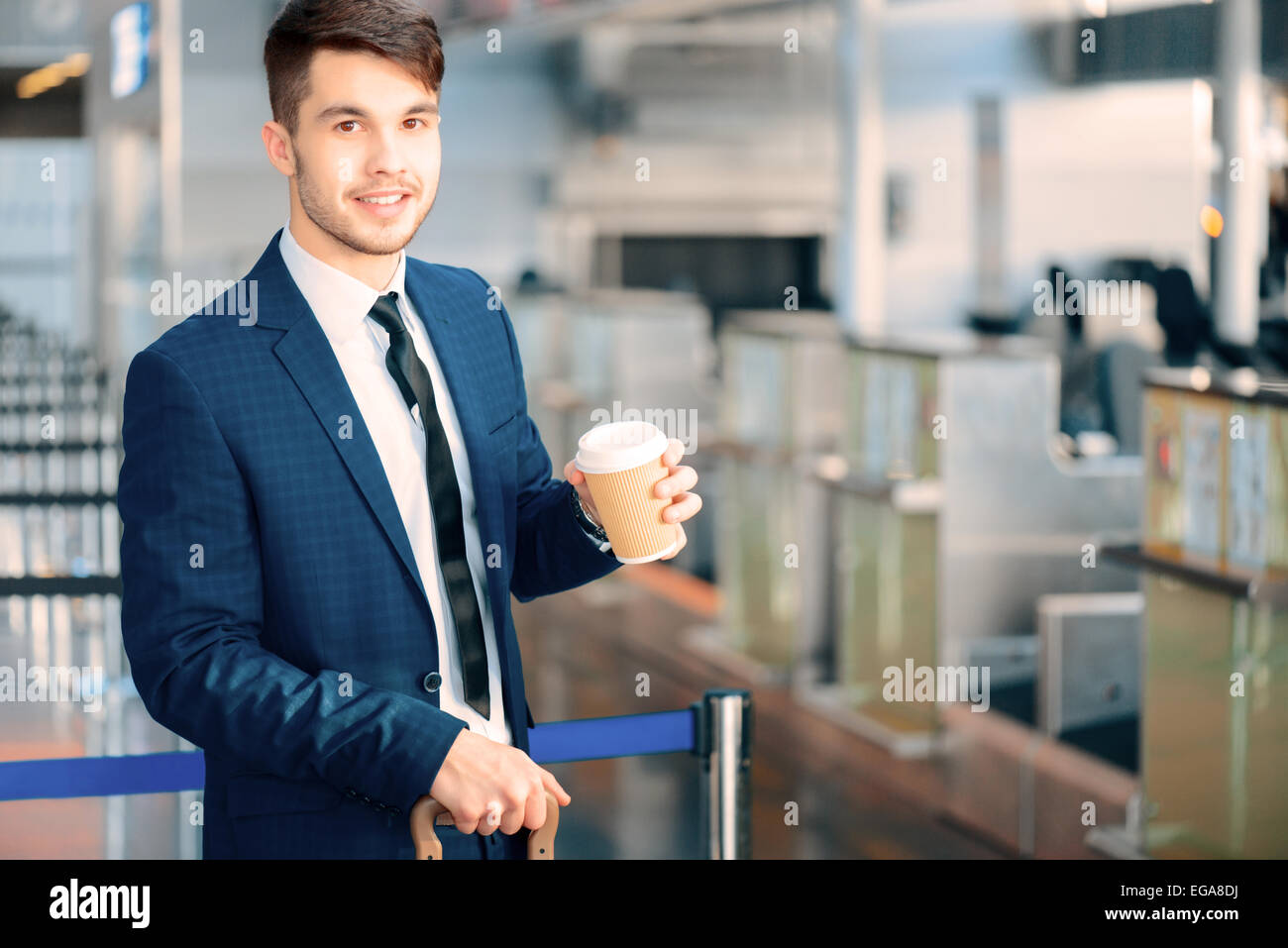 Just in time for check-in. Handsome young businessman in suit holding a ...