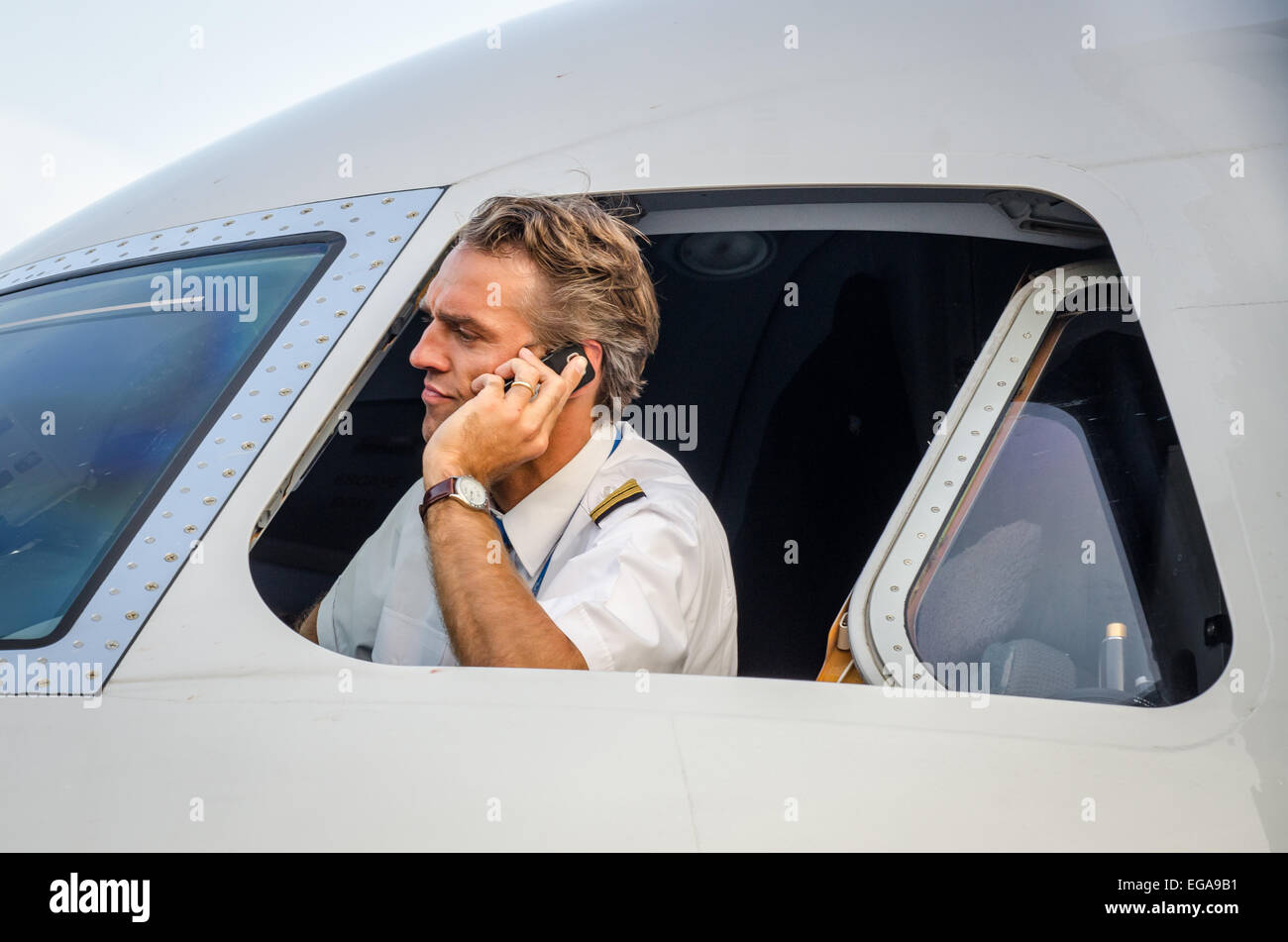 An airplane pilot calling with a cell phone Stock Photo - Alamy