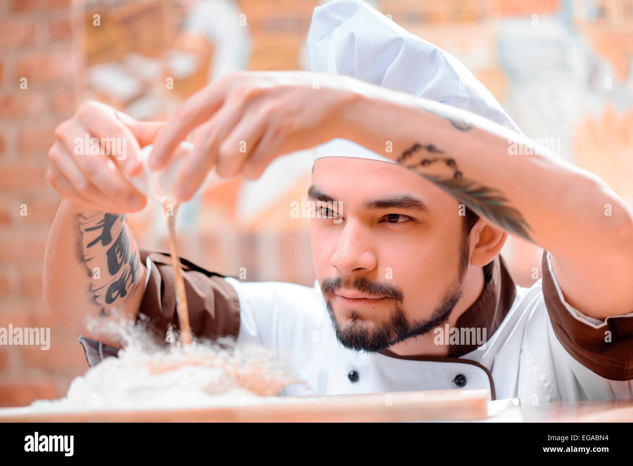 Preparing dough for pastry. Closeup image of handsome inspired cook in ...