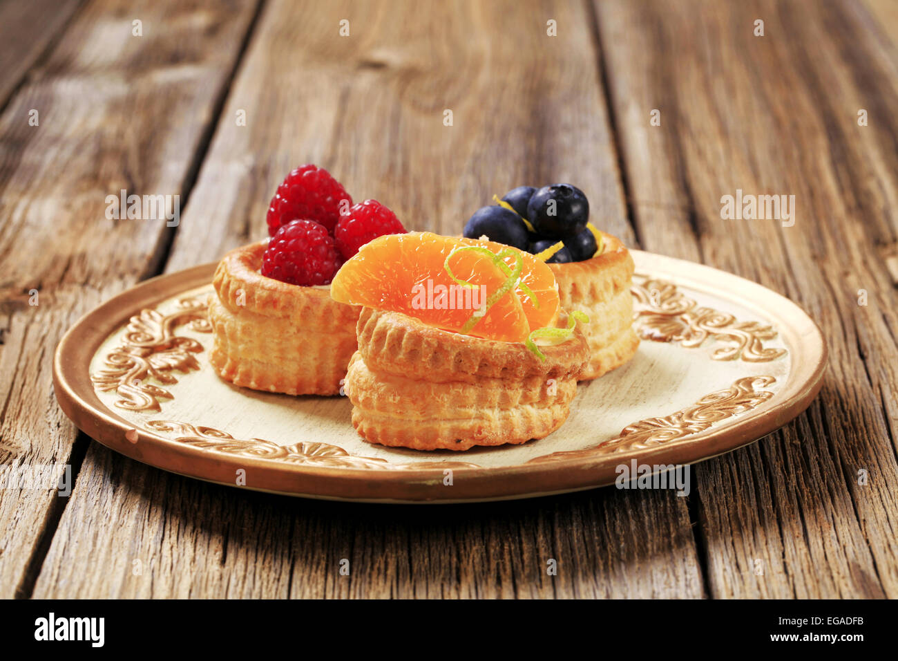 Custard filled puff pastry shells topped with fresh fruit Stock Photo ...
