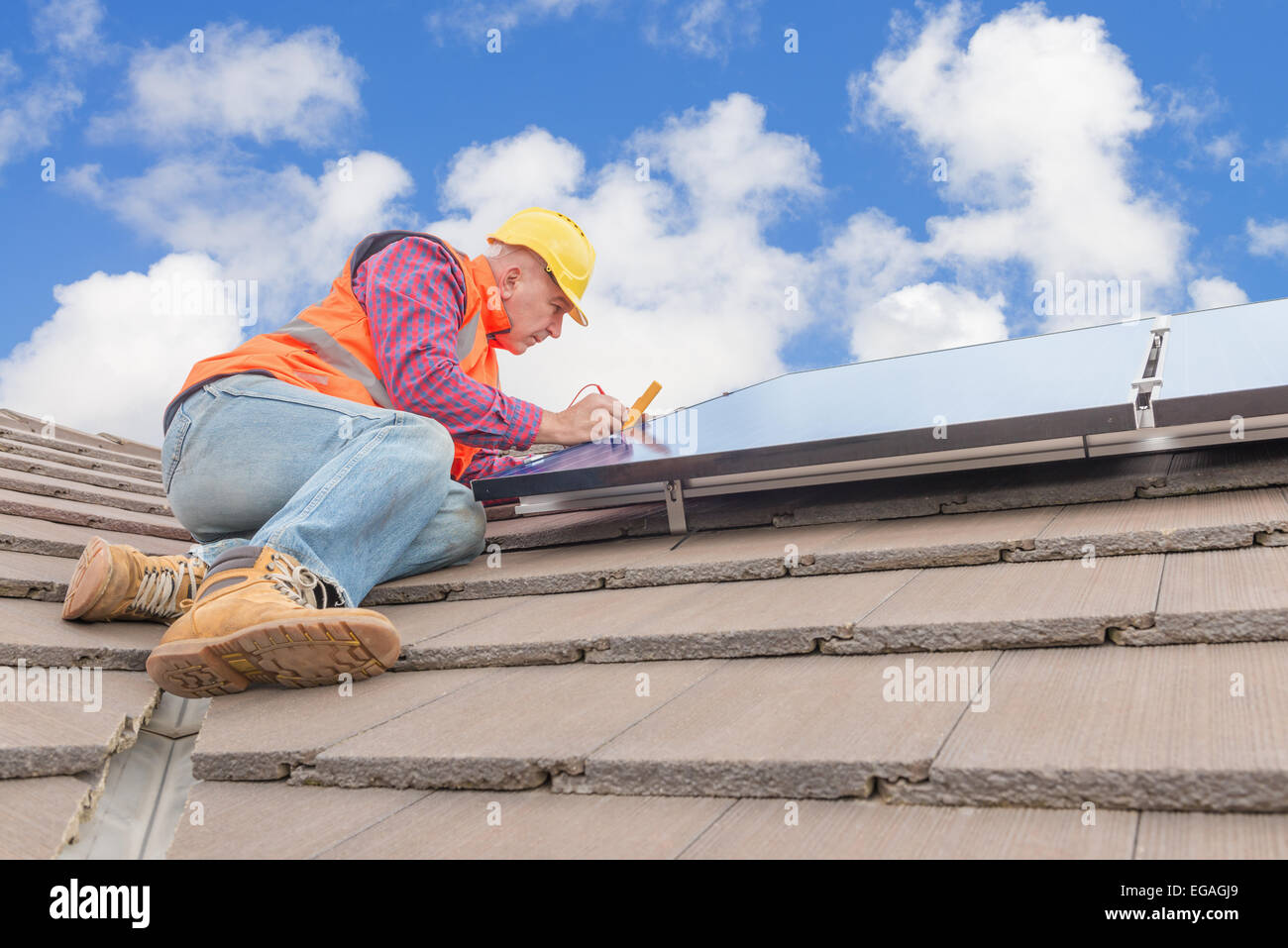 experienced worker checking solar panels on house roof Stock Photo - Alamy