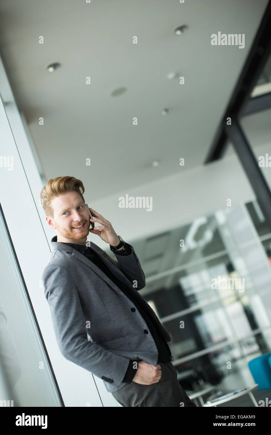 Young man with mobile phone in the office Stock Photo - Alamy