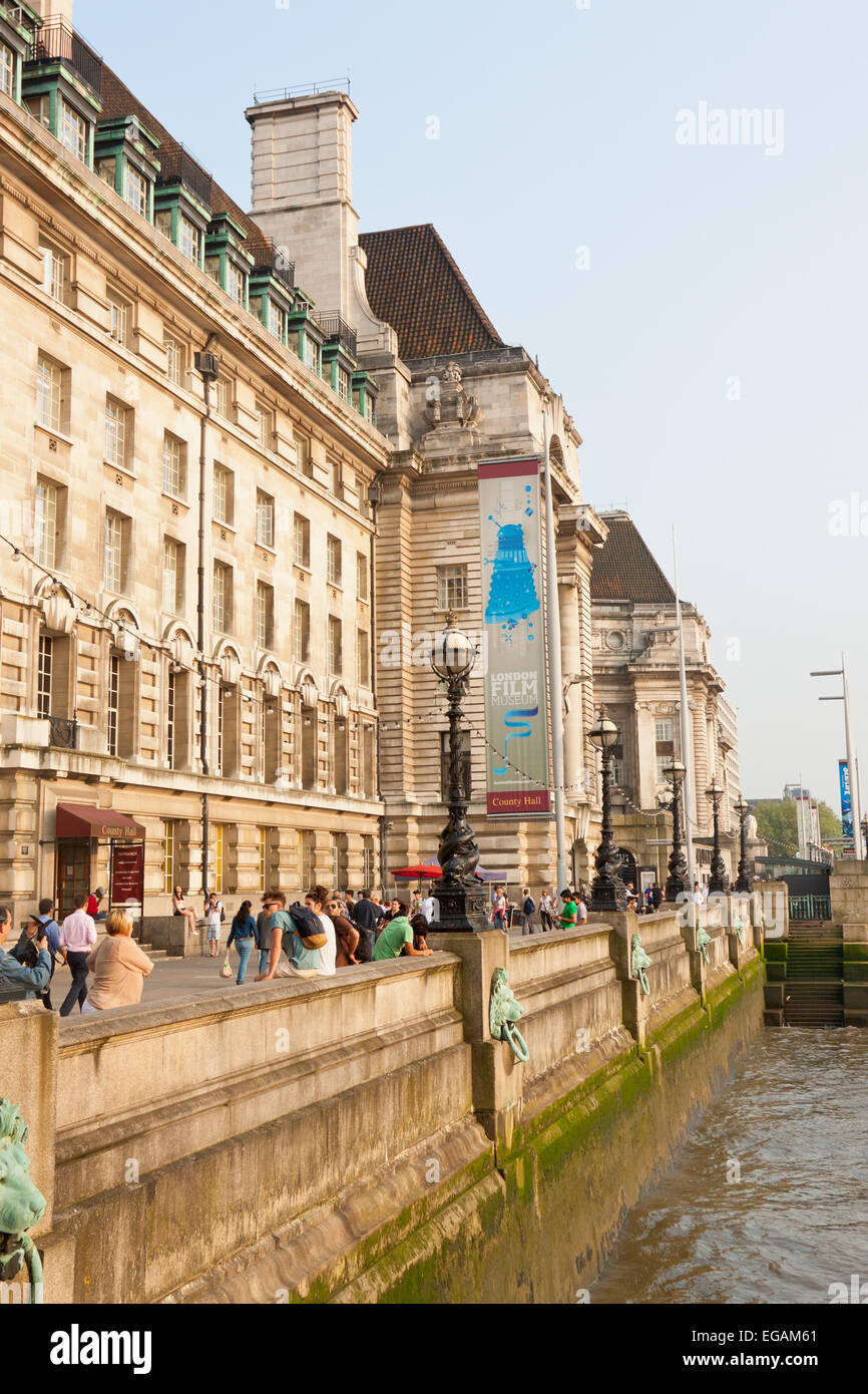 Tourists walking on the Albert Embankment and County Hall in summer ...