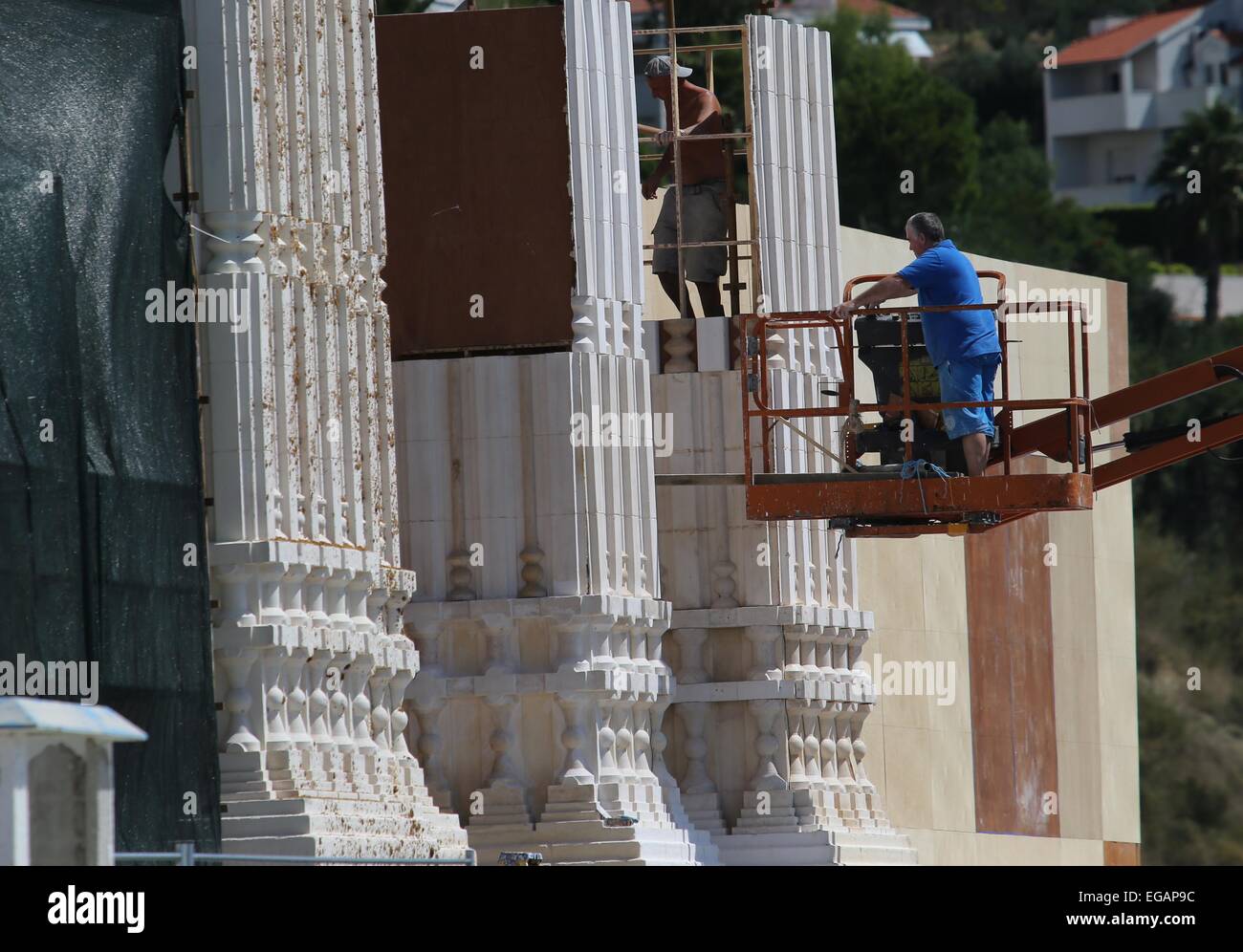 Set builders can be seen piecing together the facade of a pillared ...
