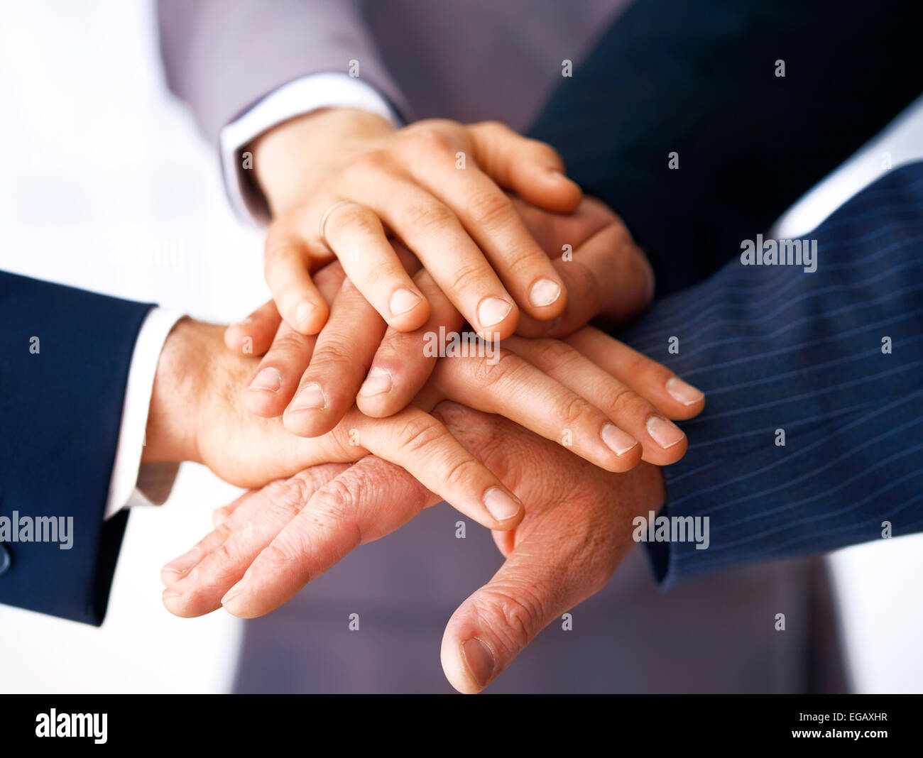 Closeup of business people's hands making a pile against a white ...