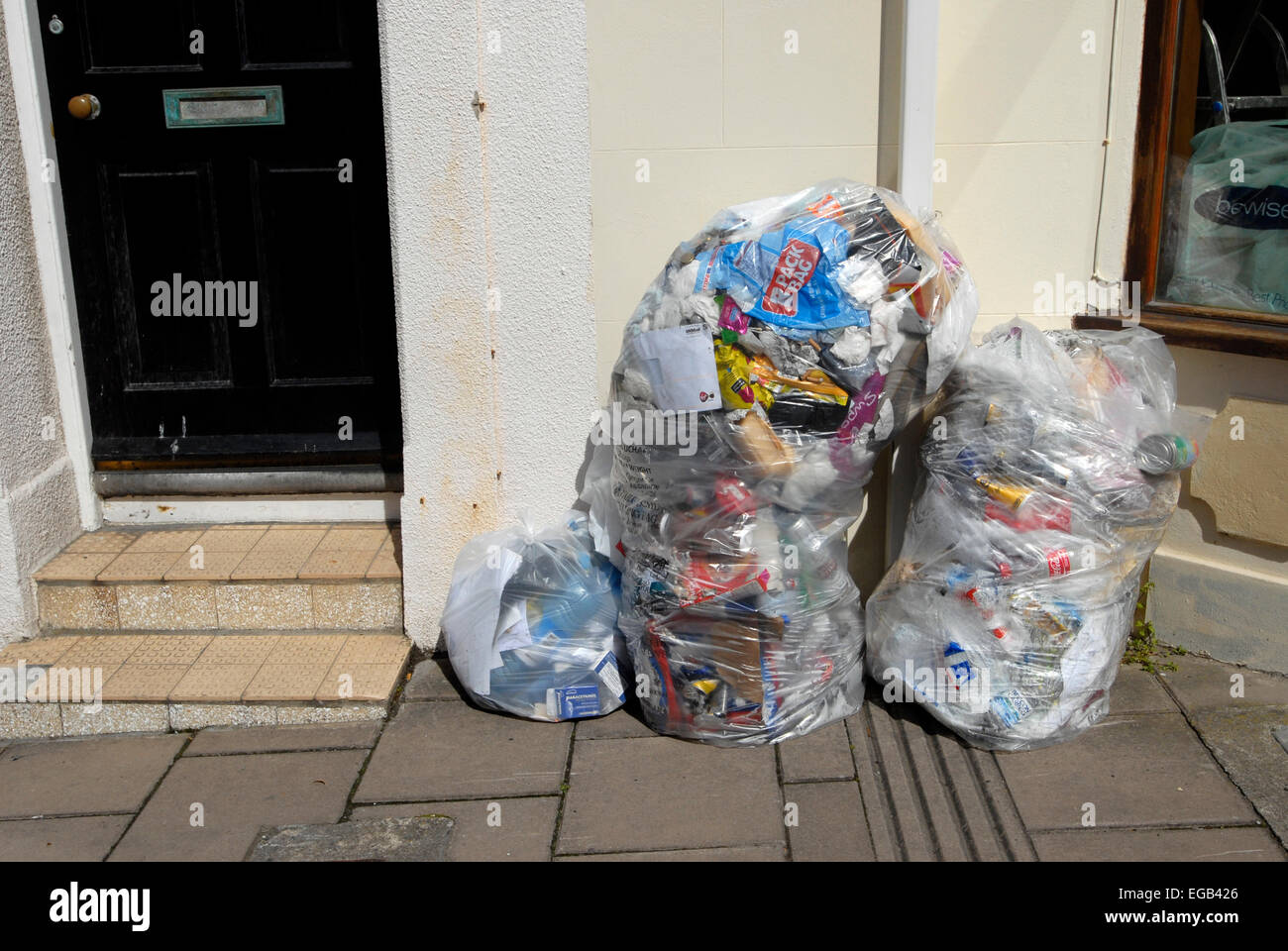 Recycling materials for collection in plastic garbage bags outside of a ...