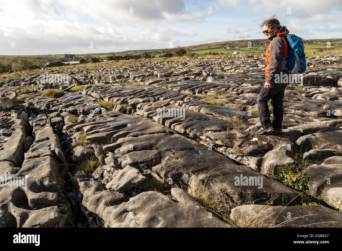 Person walking on limestone pavement at Carron, the Burren, Co. Clare ...