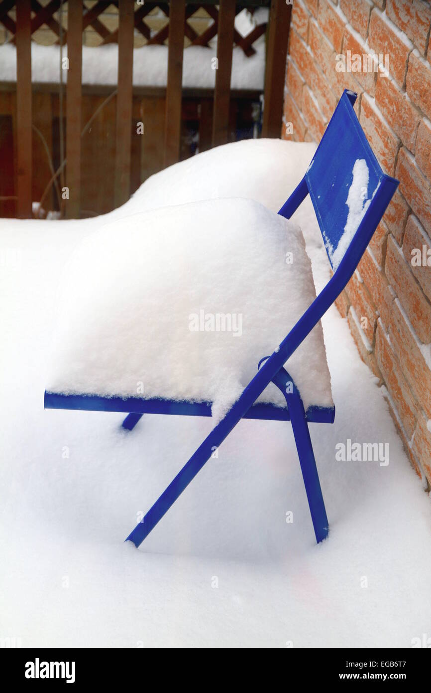 Snow covered foldable chair Stock Photo - Alamy