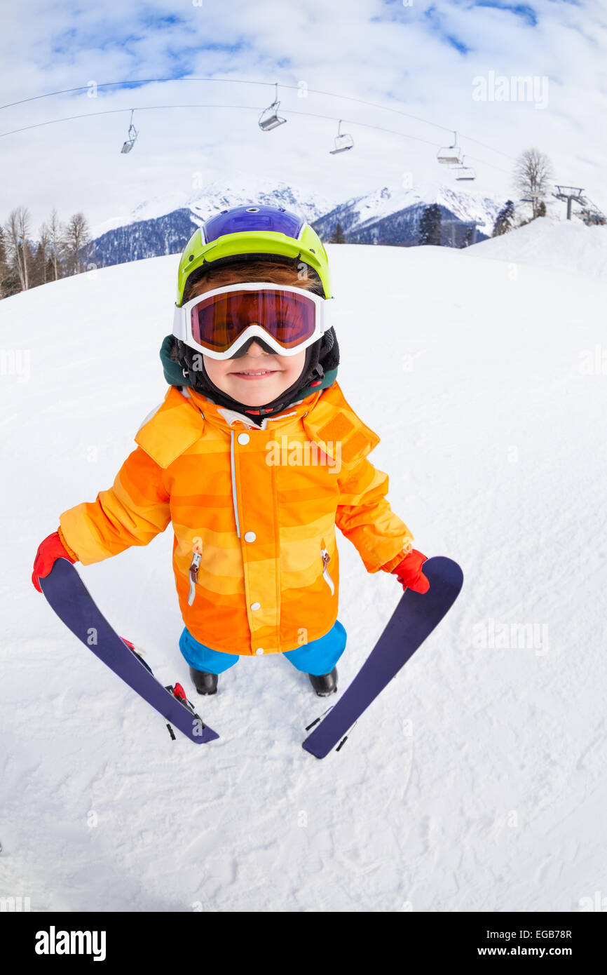 Smiling boy wearing mask holds ski in mountains Stock Photo - Alamy