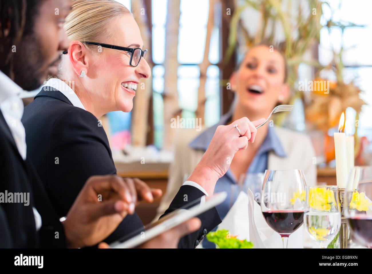 Team at business lunch meeting in restaurant eating and drinking in ...