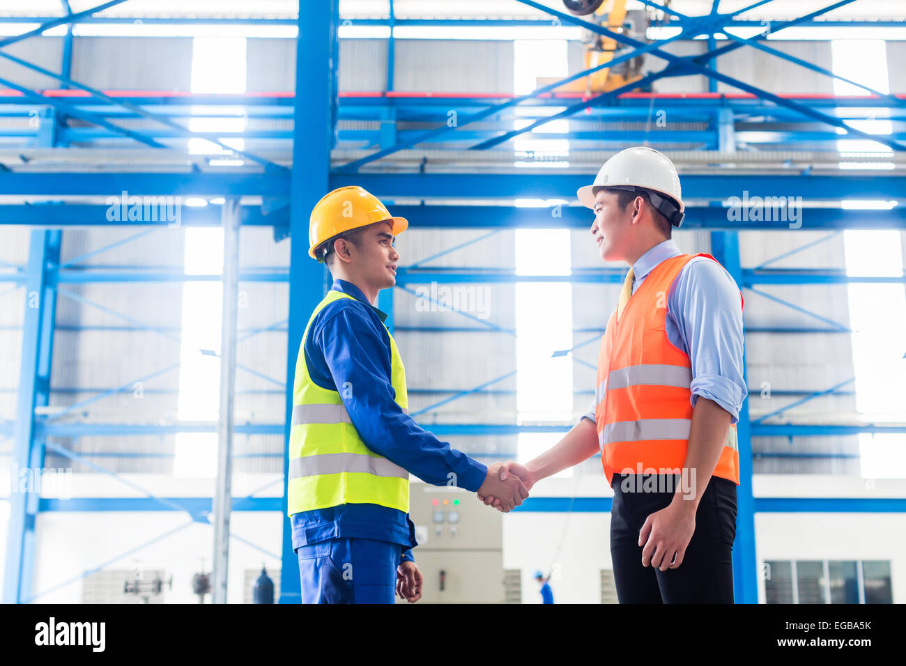 Worker and customer having agreement in factory shaking hands Stock ...