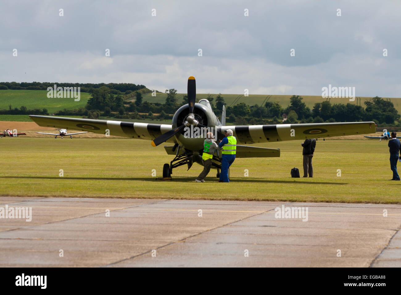 Spitfire with men turning over prop Stock Photo - Alamy