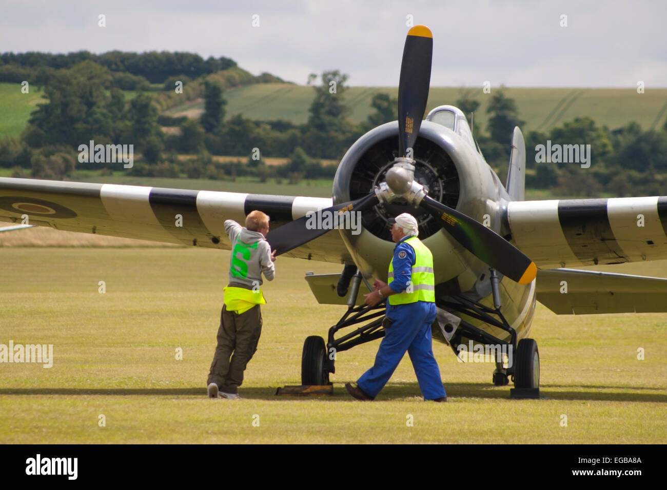 Spitfire with men turning over prop Stock Photo - Alamy