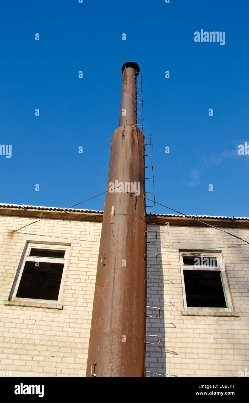 industrial house ruins with old metal smokestack chimney and two ...